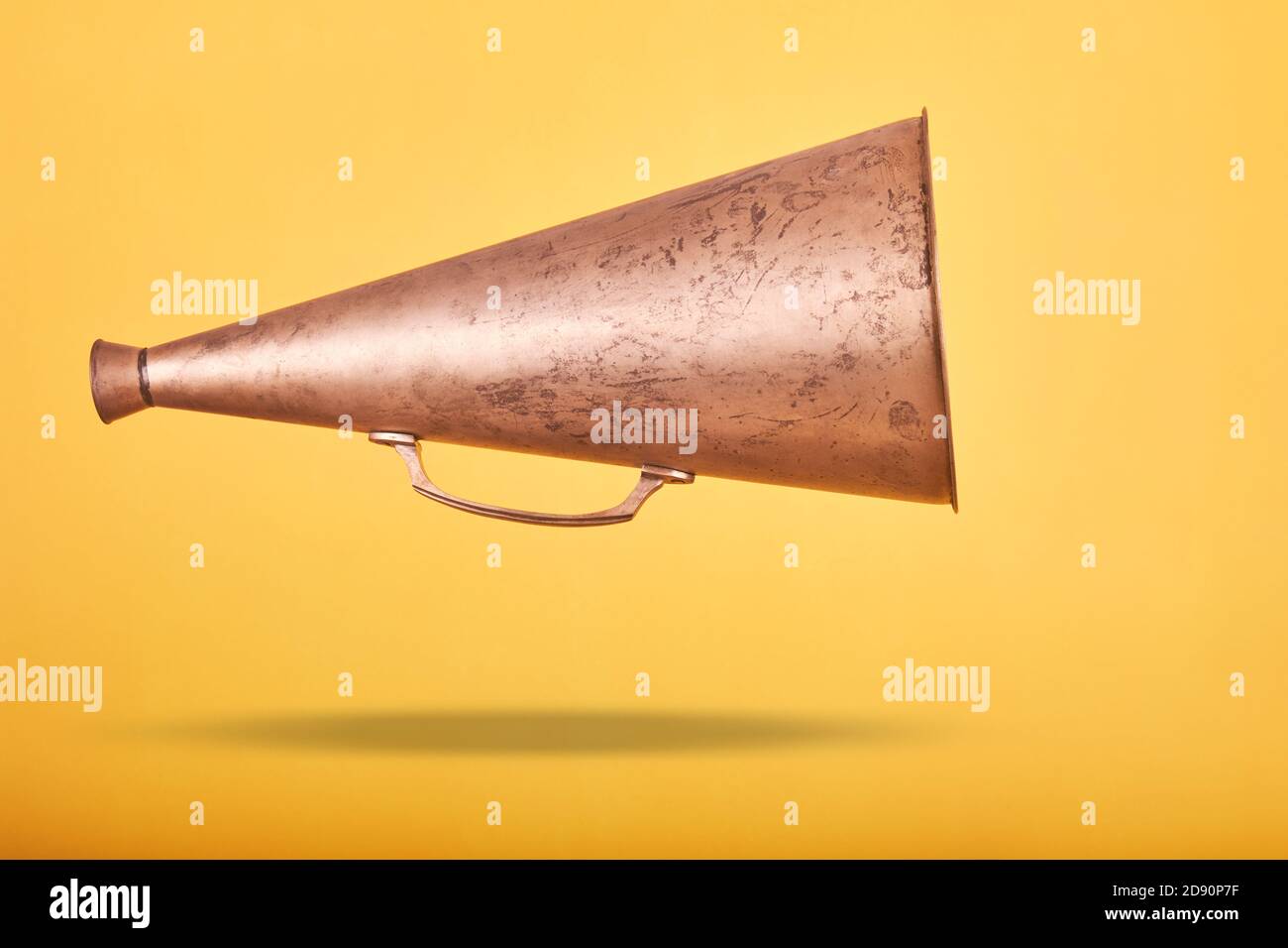 old megaphone on a yellow background Stock Photo - Alamy