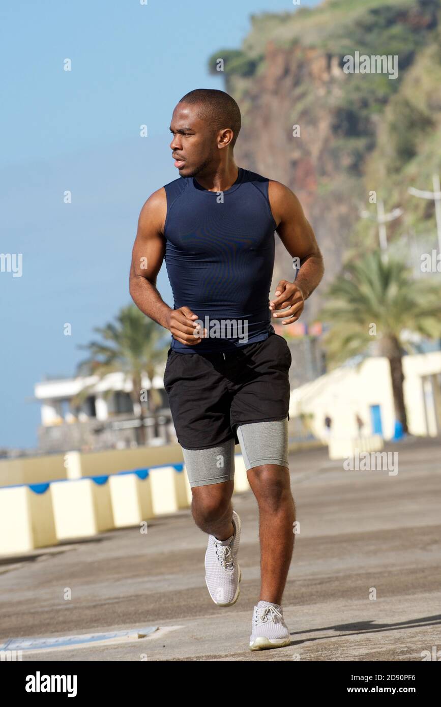Full length portrait of young black man jogging outdoors Stock Photo ...