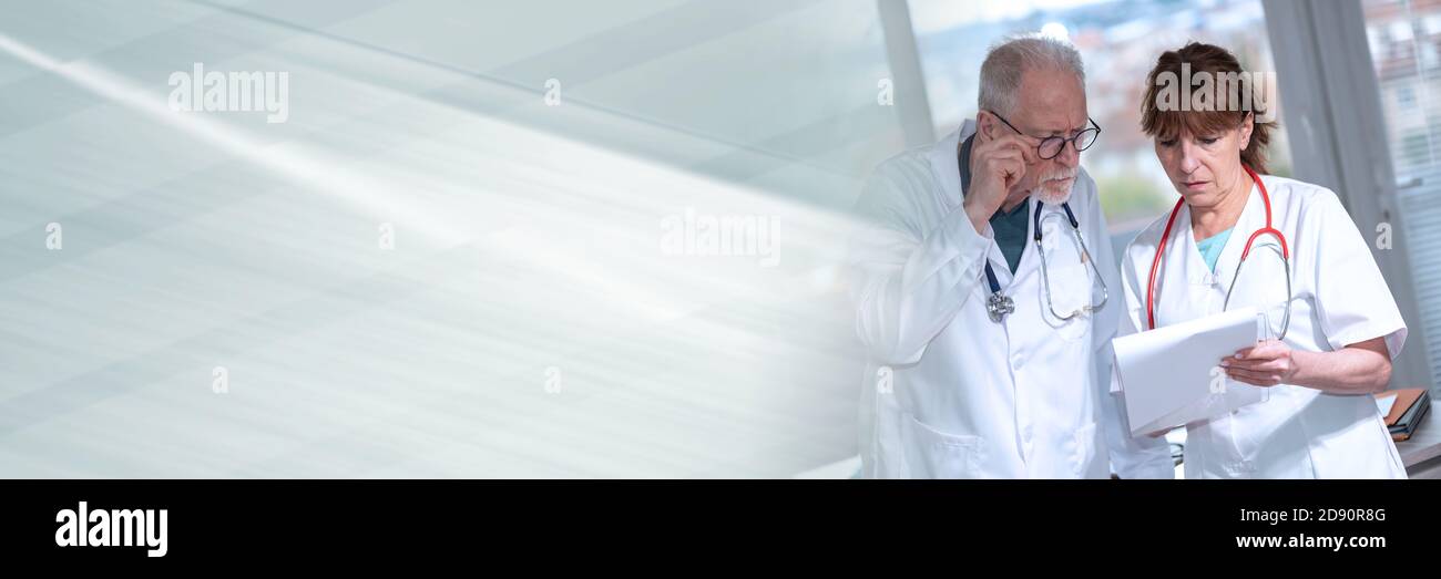 Two doctors discussing about medical report in clinic; panoramic banner ...
