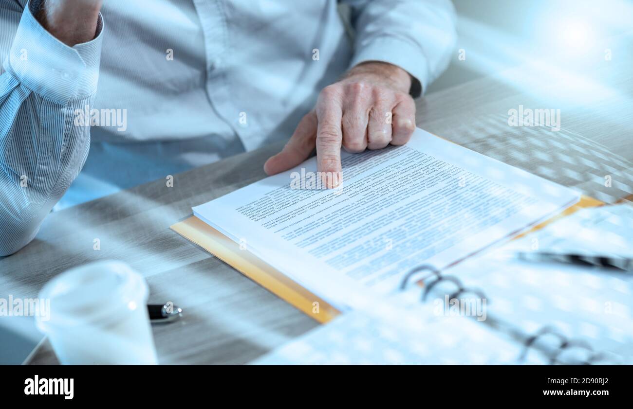 Businessman checking a document in office; light effect Stock Photo - Alamy