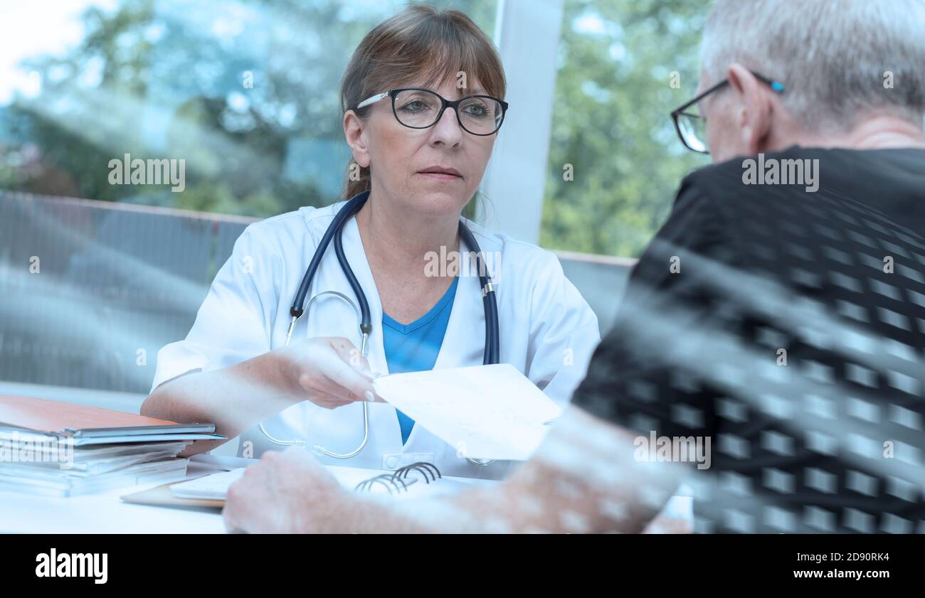 Female doctor giving prescription to her patient in medical office ...