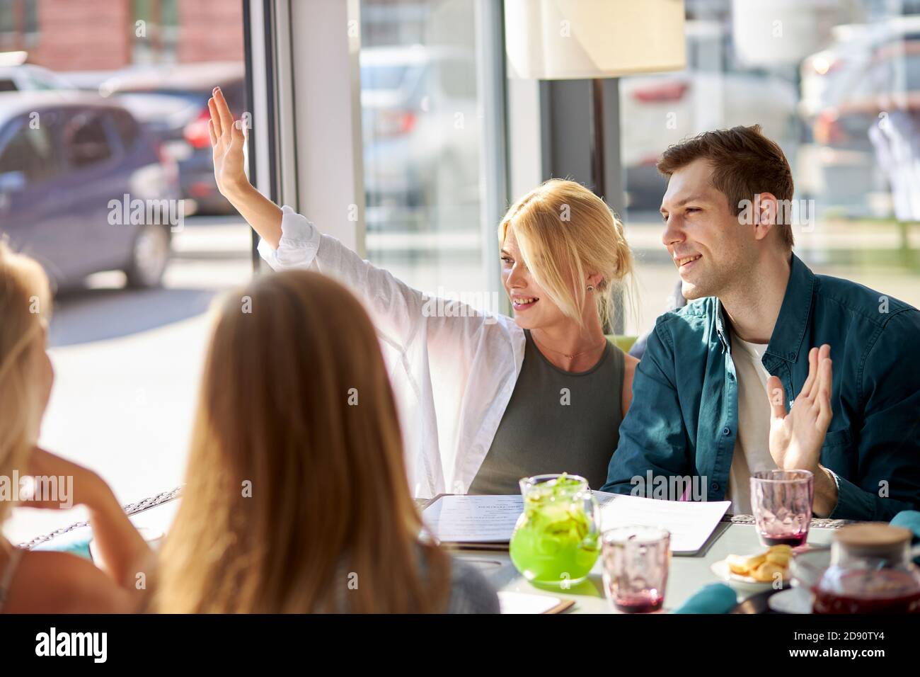 young people are waiting for friend in cafe, they have seen friend ...