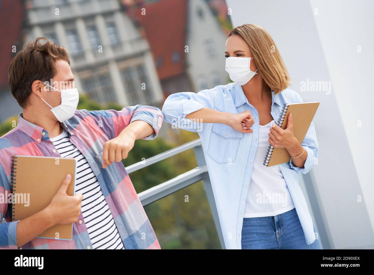 Couple of students wearing masks while saying hi in the campus Stock ...