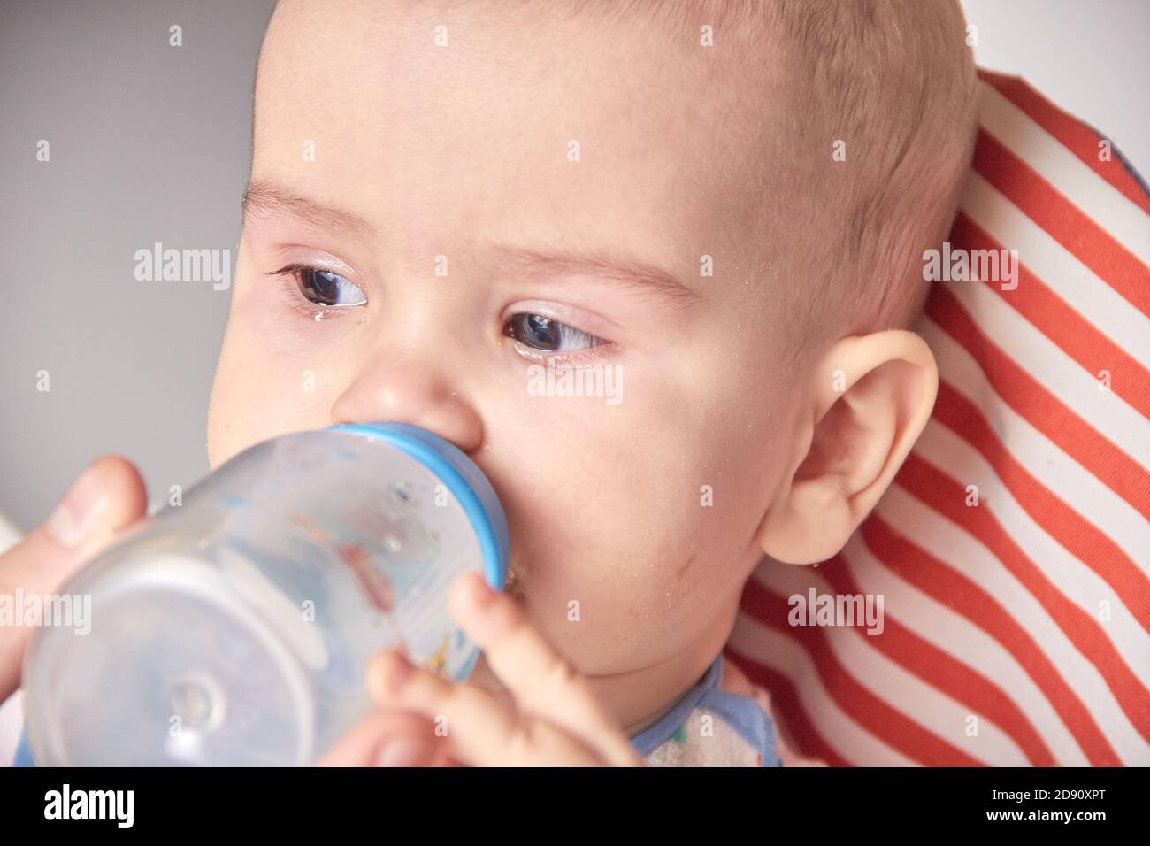 Giving to drink water baby from bottle, closeup Stock Photo - Alamy