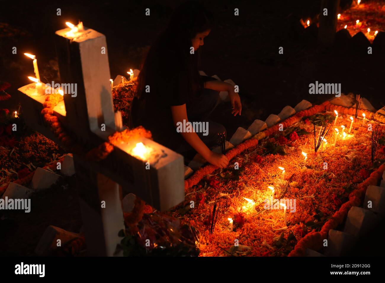 A catholic family member offers prayers for the dead at a Dhaka ...