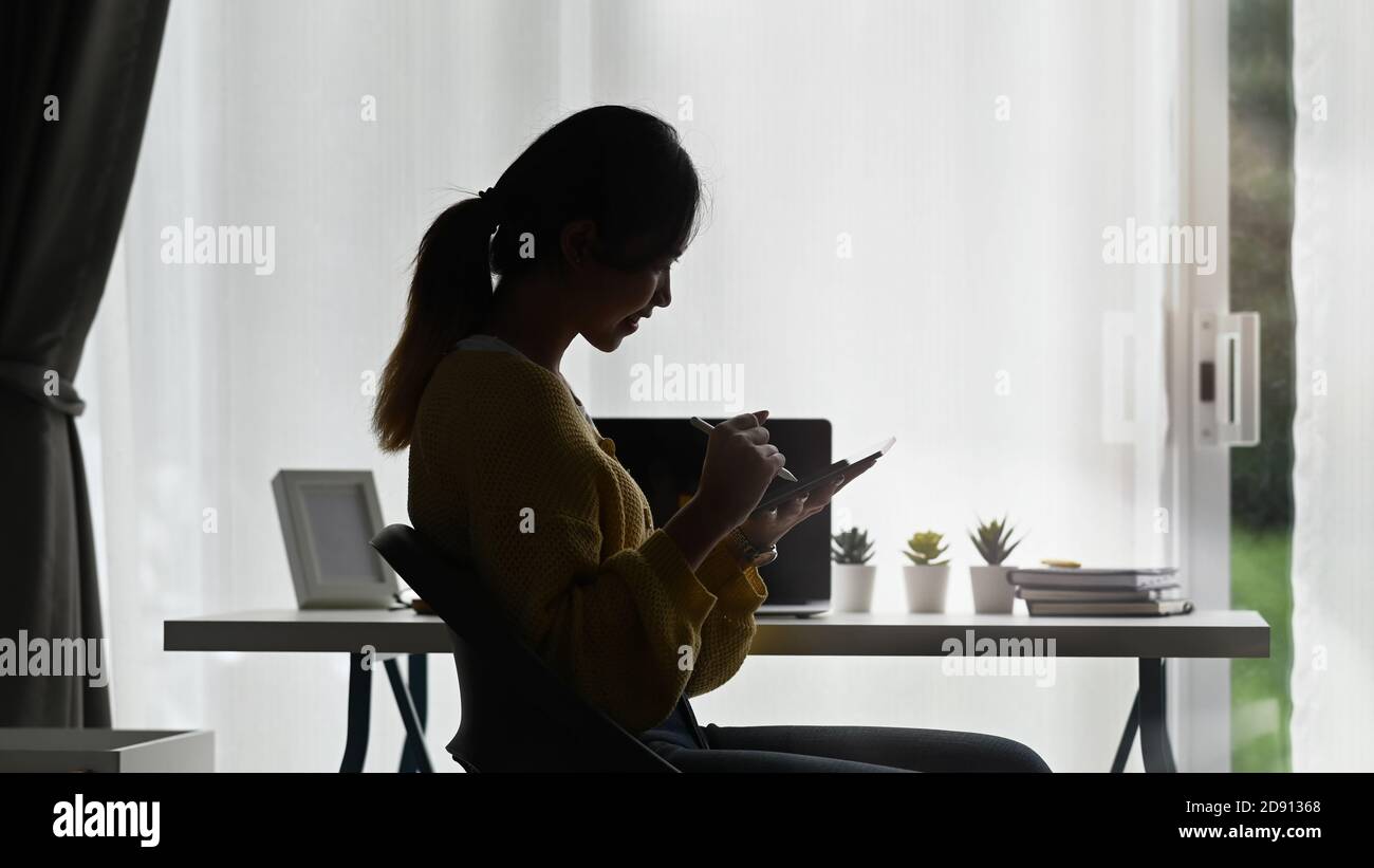 Side view of businesswoman working on tablet while sitting in modern ...