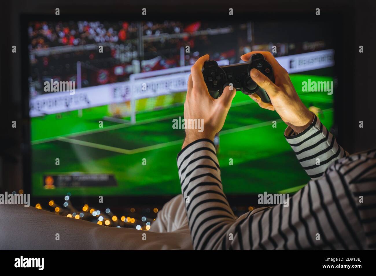 Young hipster man playing video game football on console. gamer guy ...