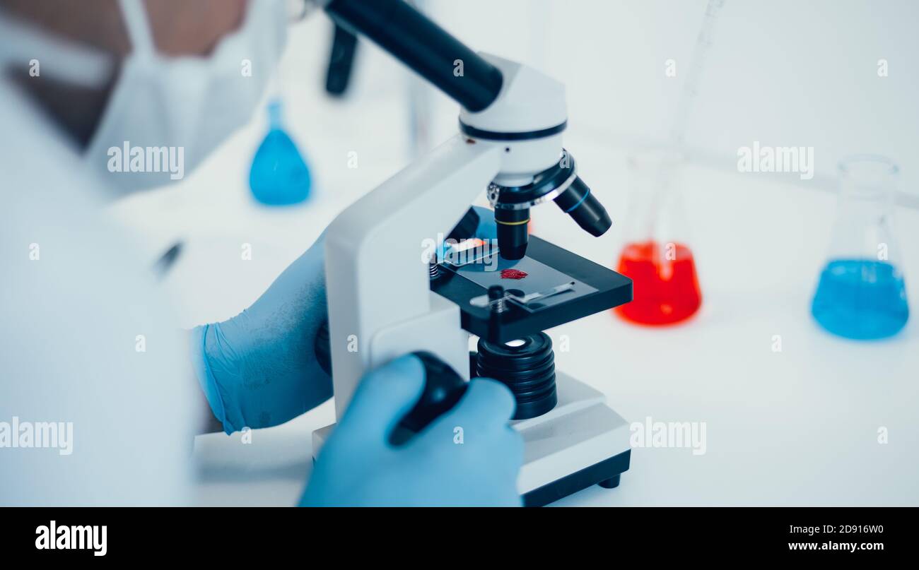 close up. scientist setting up his microscope to work Stock Photo - Alamy
