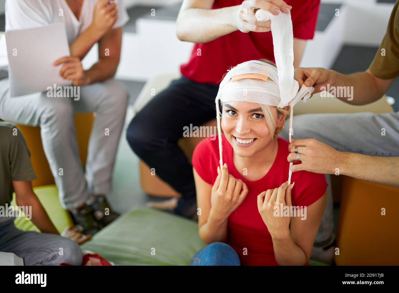 group of young caucasian people practice treating a patient by bandages ...