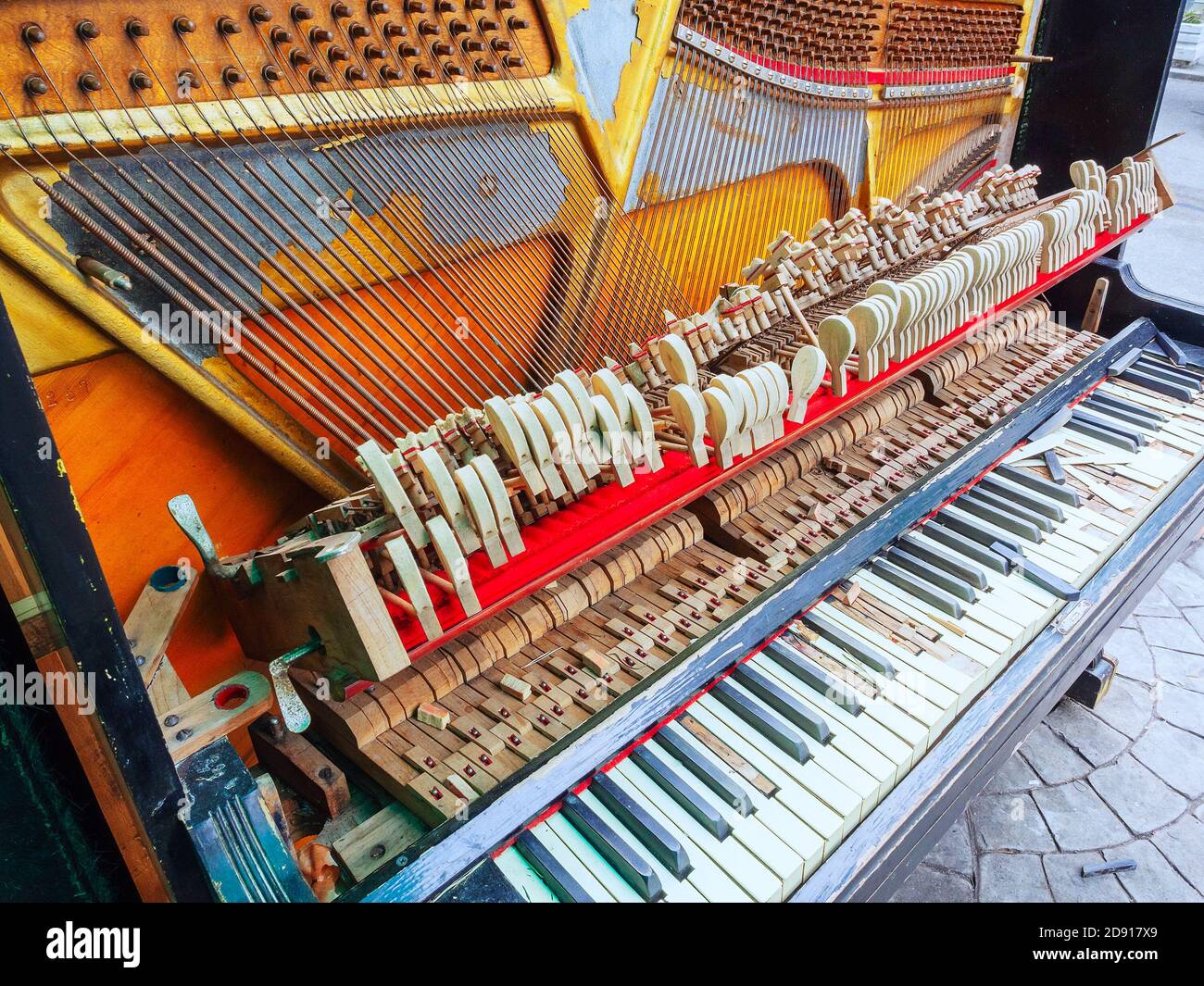 An old broken piano with a missing wall and broken keys Stock Photo - Alamy