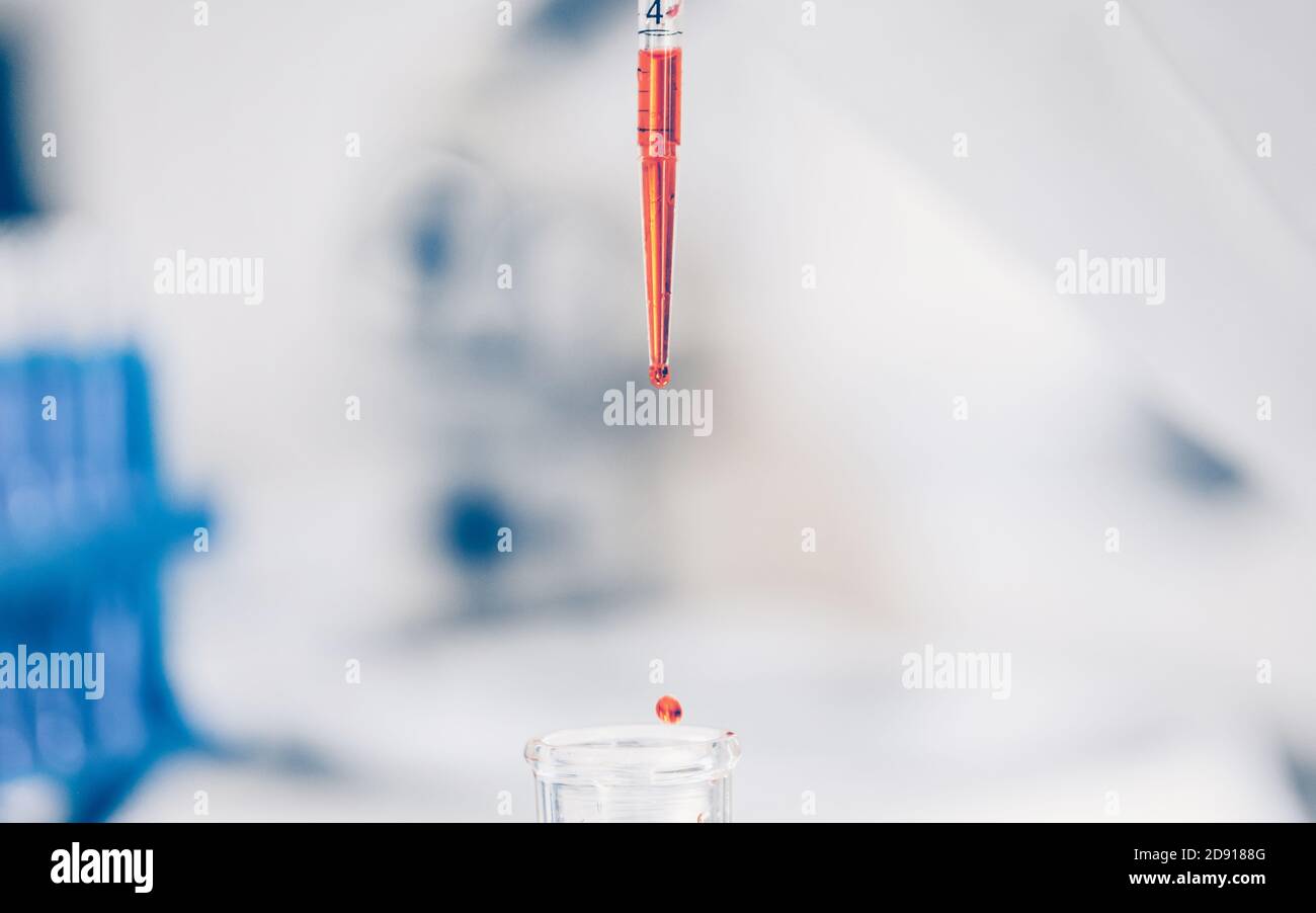 red liquid in a laboratory pipette on a blurry background Stock Photo ...