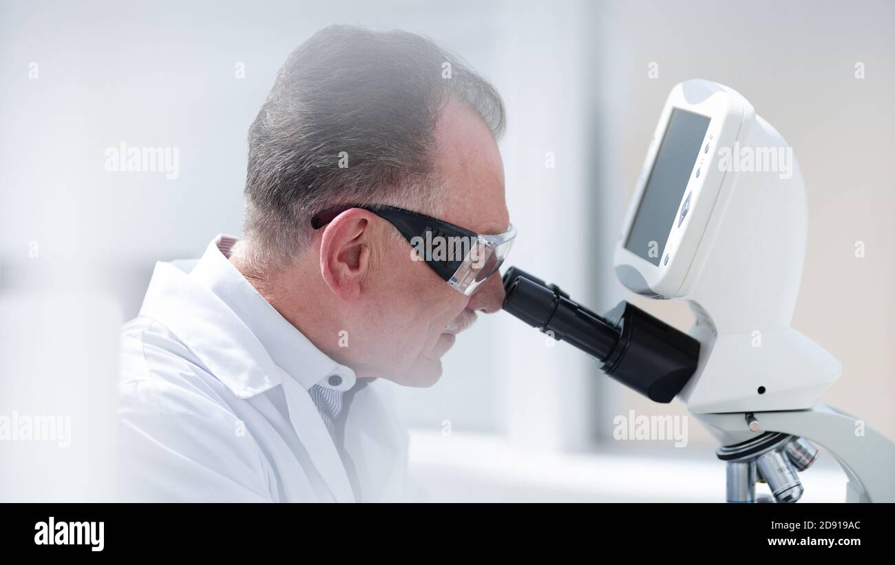 close up. scientist looking carefully through a microscope Stock Photo ...