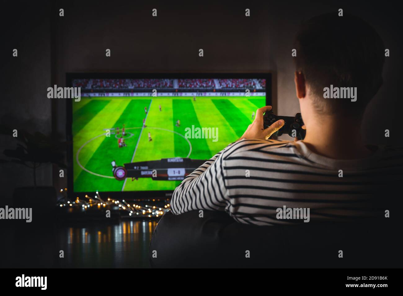 Young hipster man playing video game football soccer on console. gamer ...