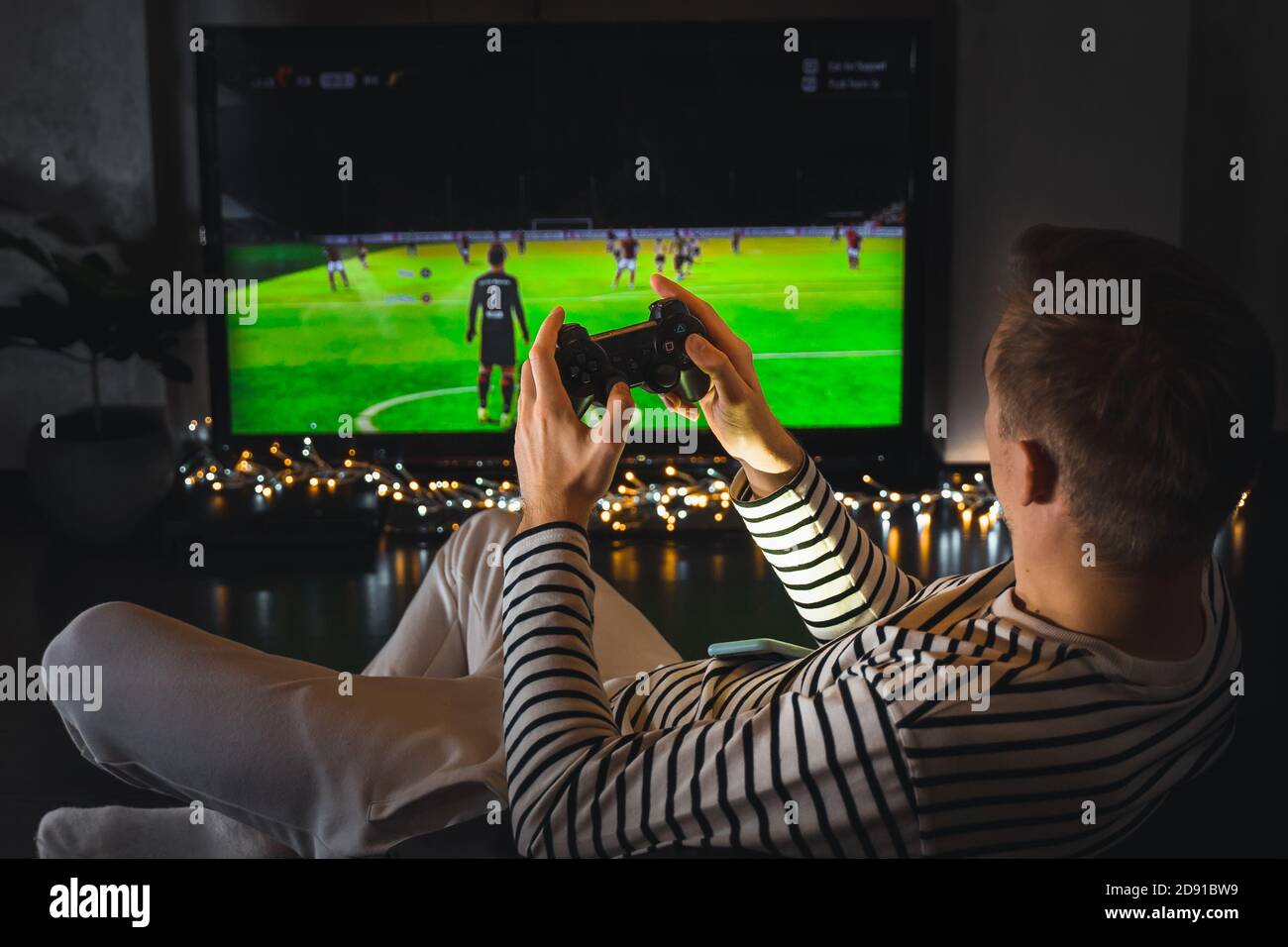 Young hipster man playing video game football soccer on console. gamer ...