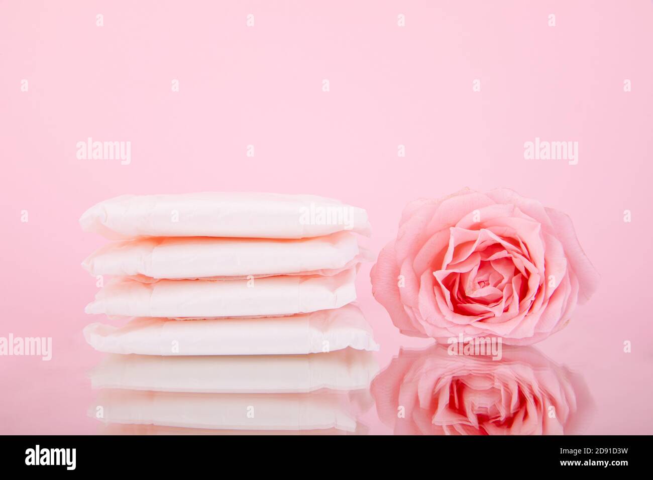 Sanitary pads and a rose on a pink background Stock Photo - Alamy