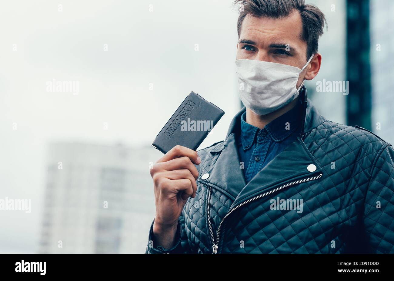 young man in a protective mask showing his passport Stock Photo - Alamy