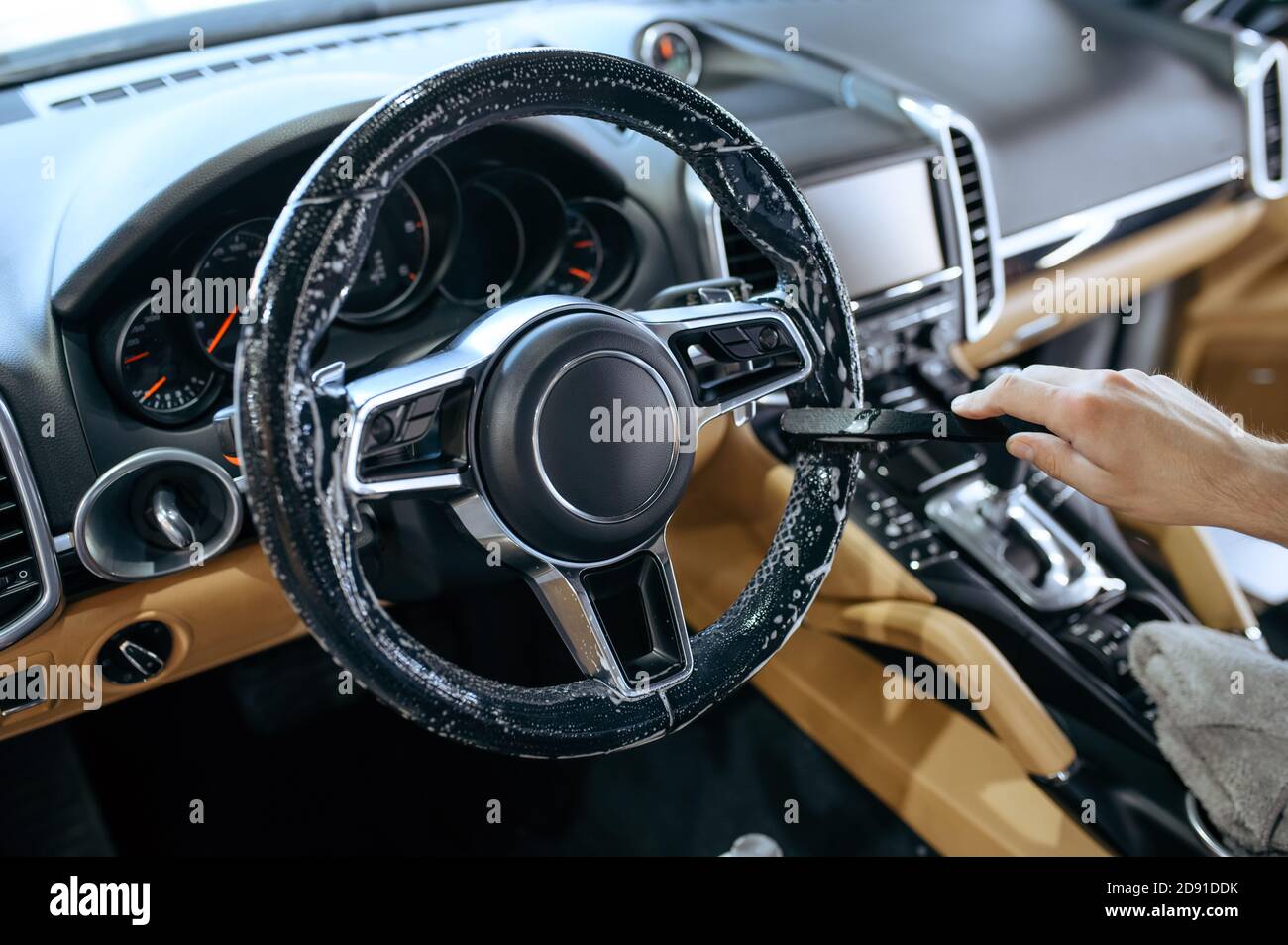 Worker wipes car steering wheel, detailing Stock Photo - Alamy