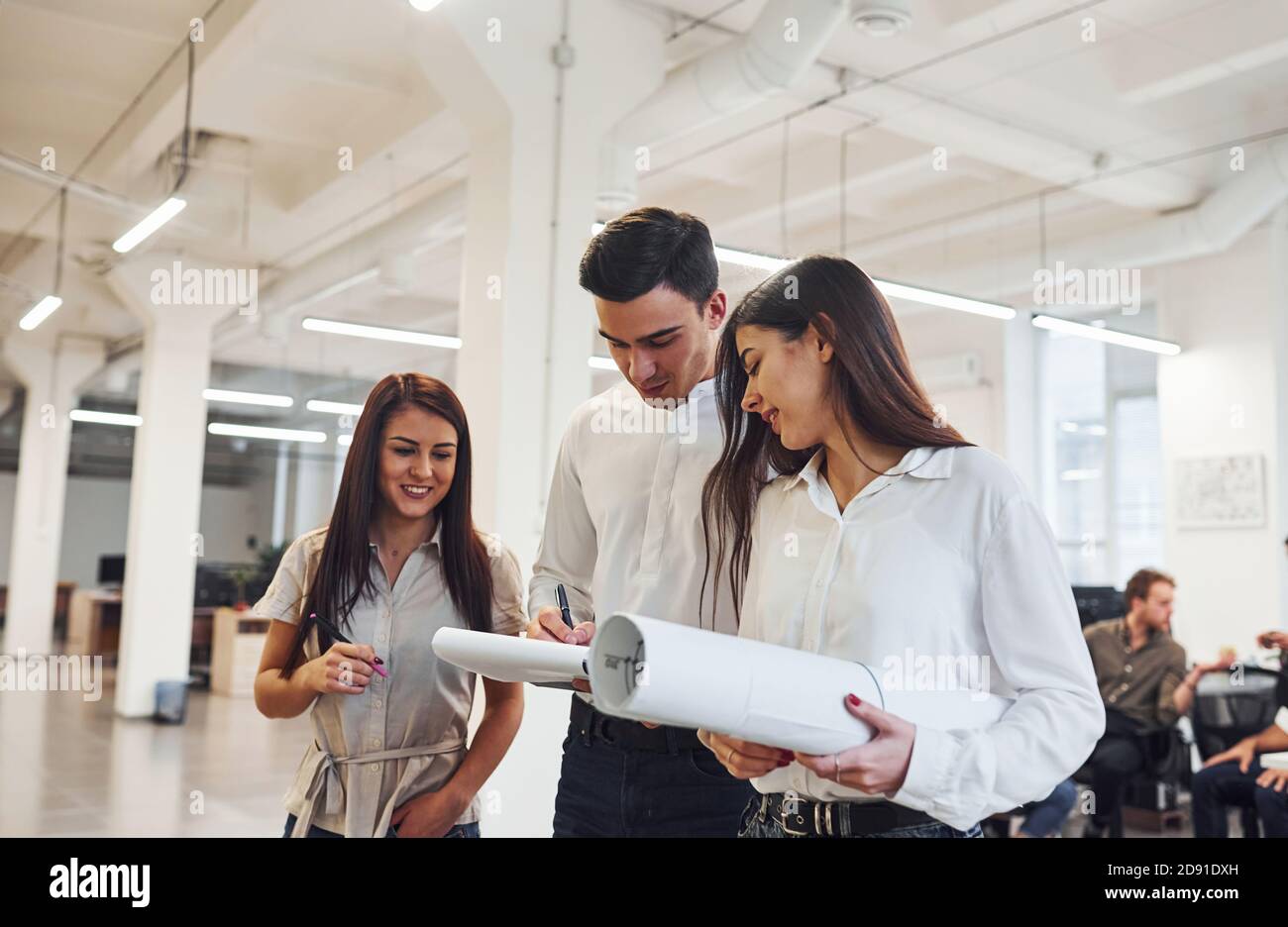 Group of young employees talking and working at new project in the ...