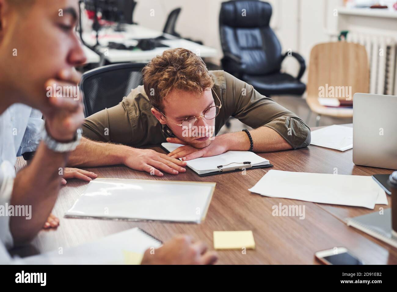 Sitting by the table. Young business people working together in the ...