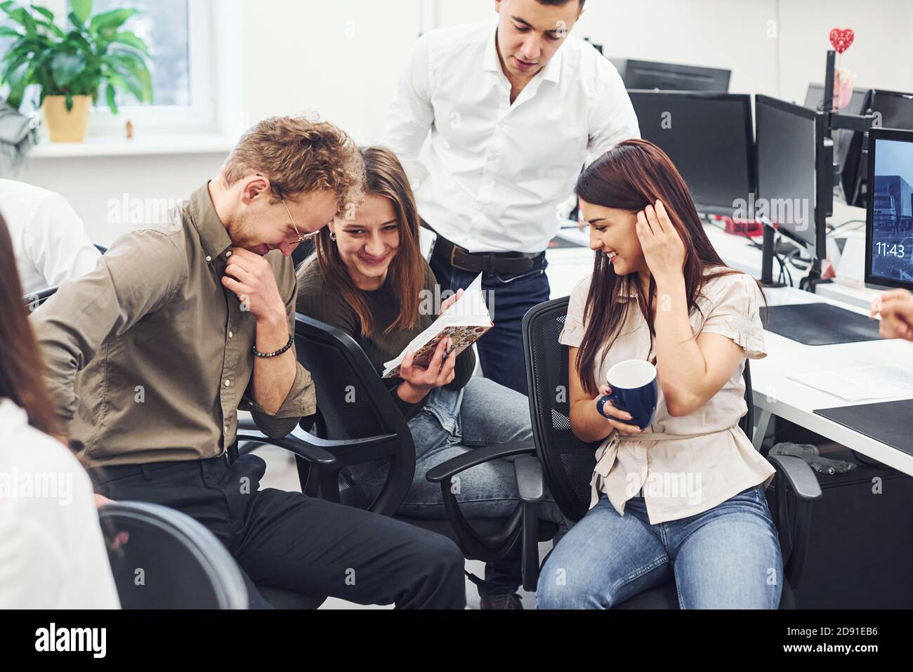 Young business people sitting by the table, talking and working ...
