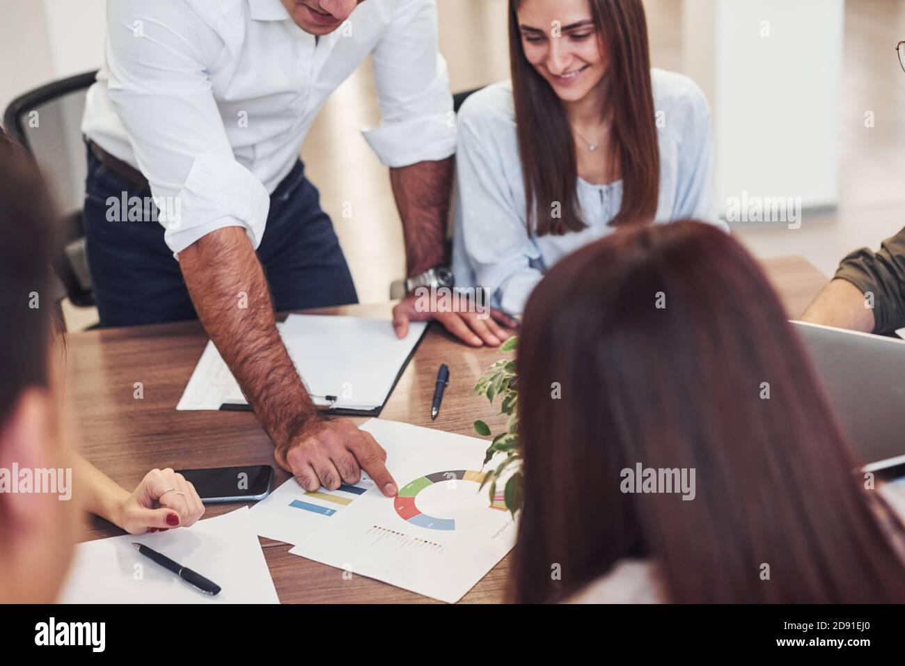 Sitting by the table. Young business people working together in the ...