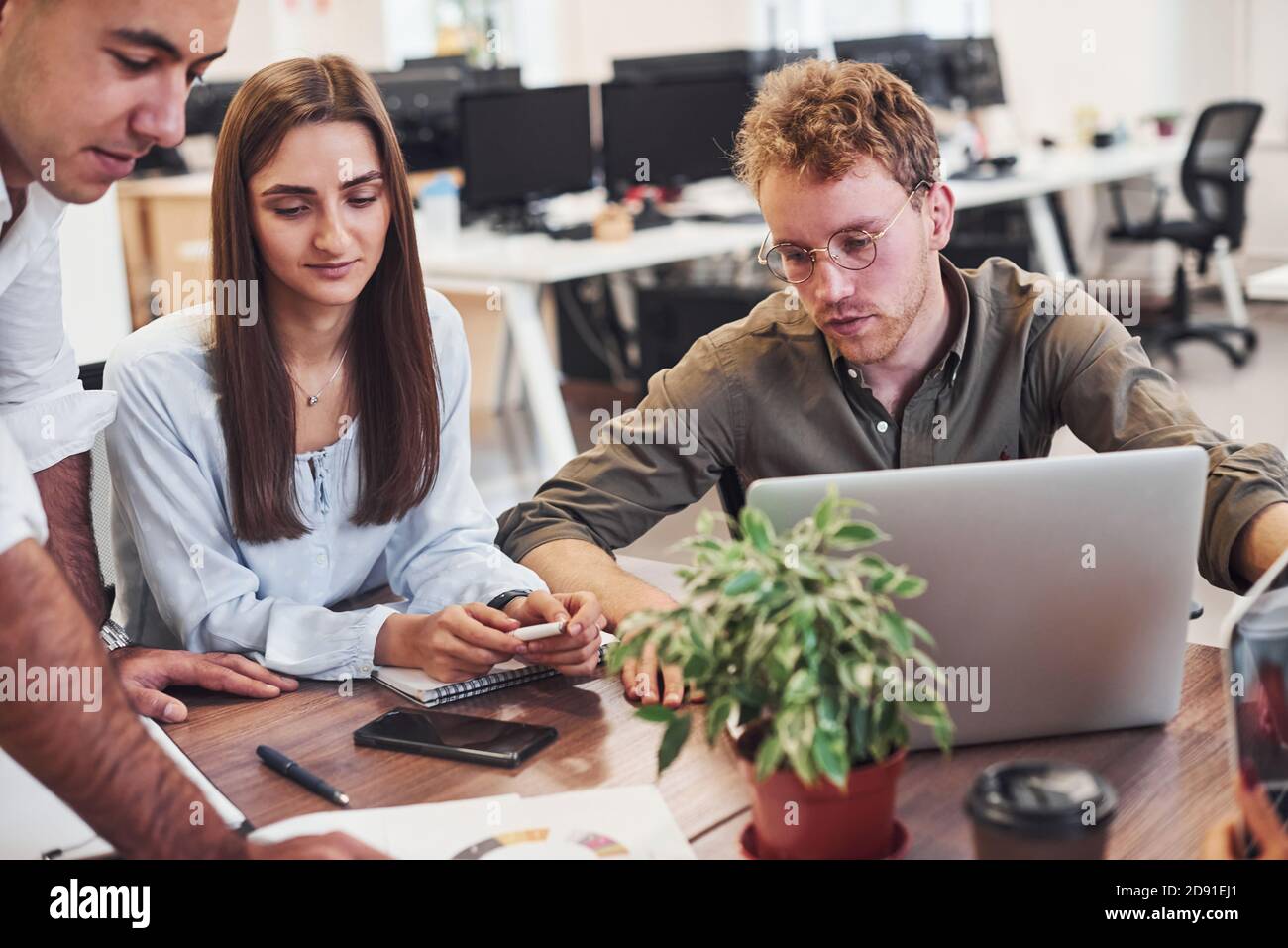Sitting by the table. Young business people working together in the ...