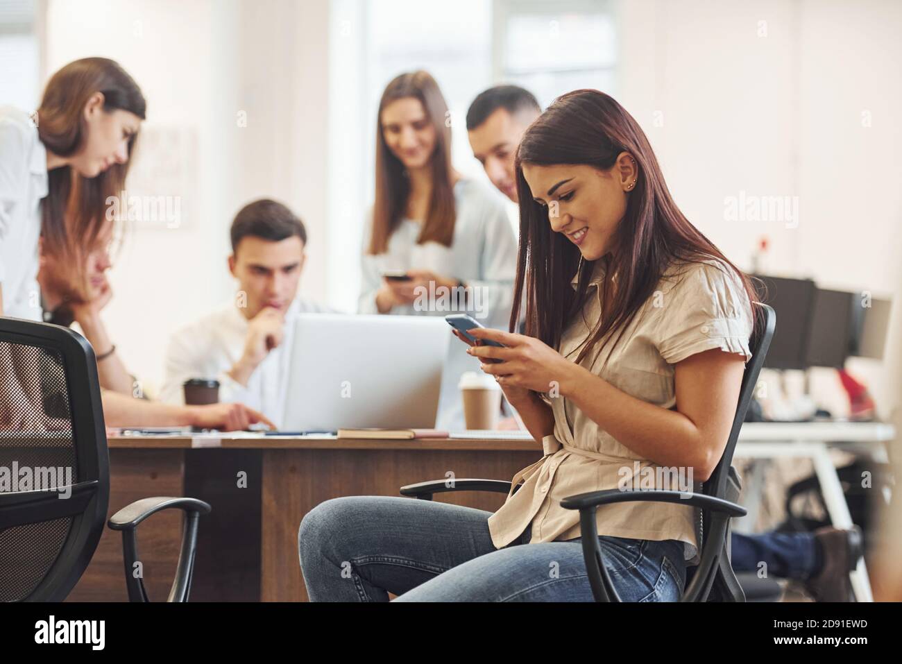 Sitting by the table. Young business people working together in the ...