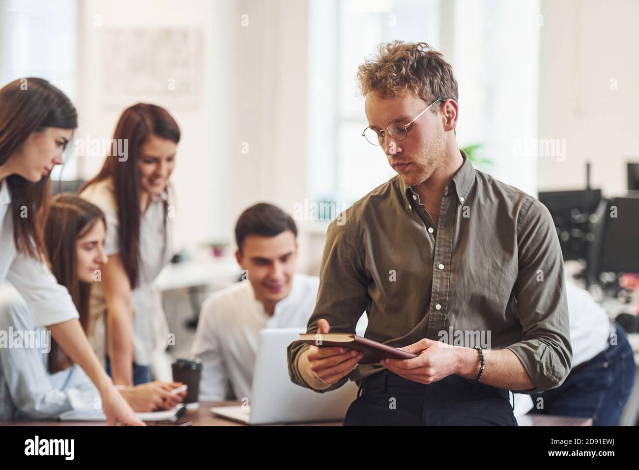 Sitting by the table. Young business people working together in the ...