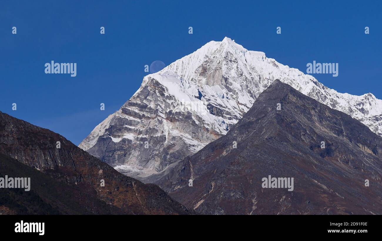 Spectacular view of full moon rising above majestic ice-capped mountain ...