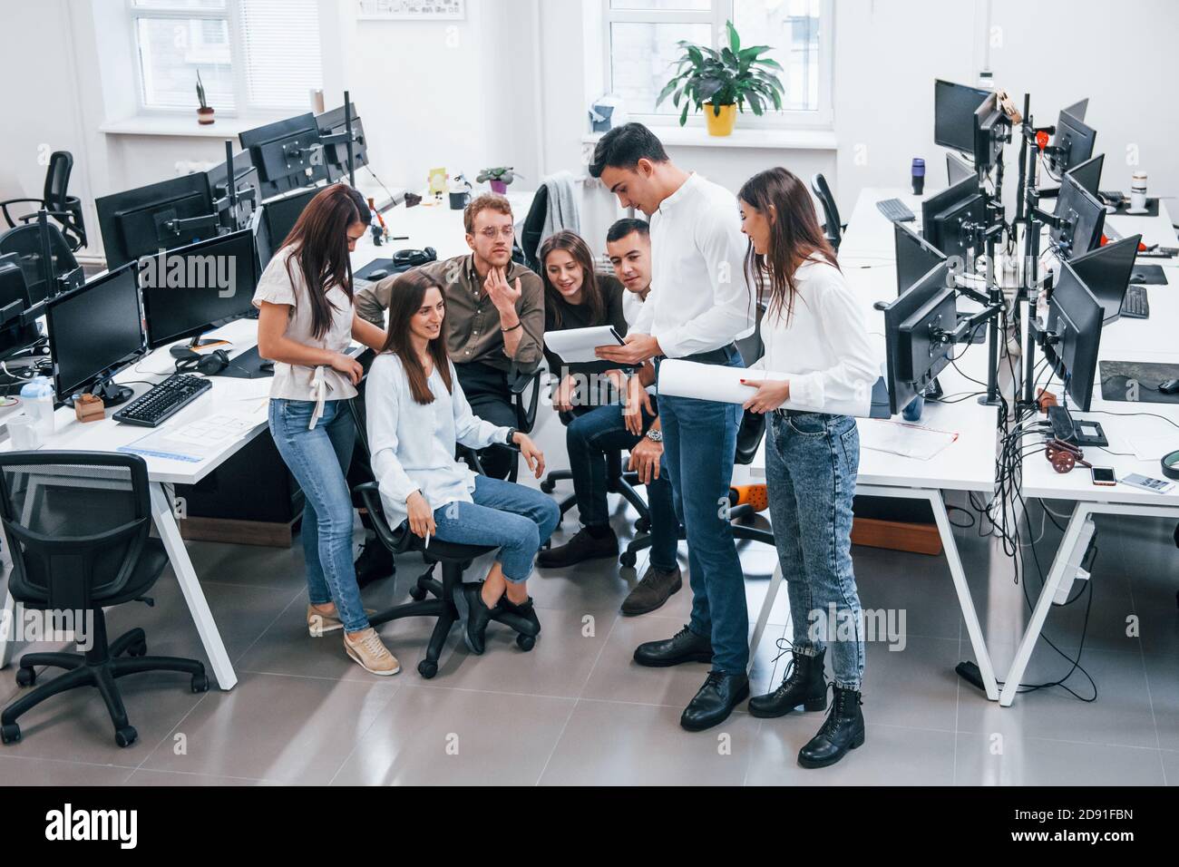 People talking and working together in the modern office near computers ...