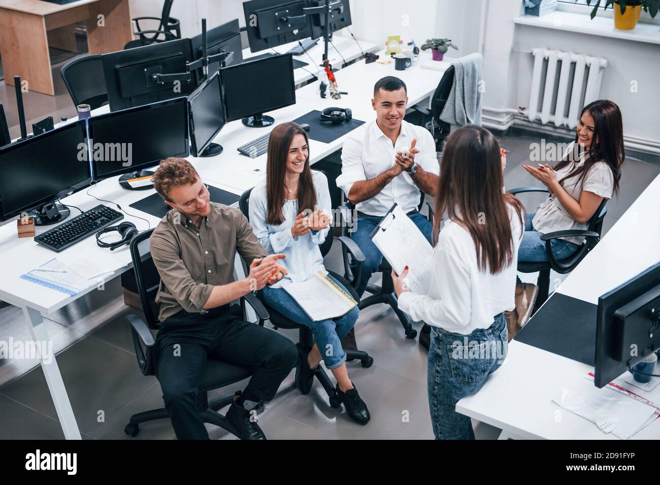 People talking and working together in the modern office near computers ...