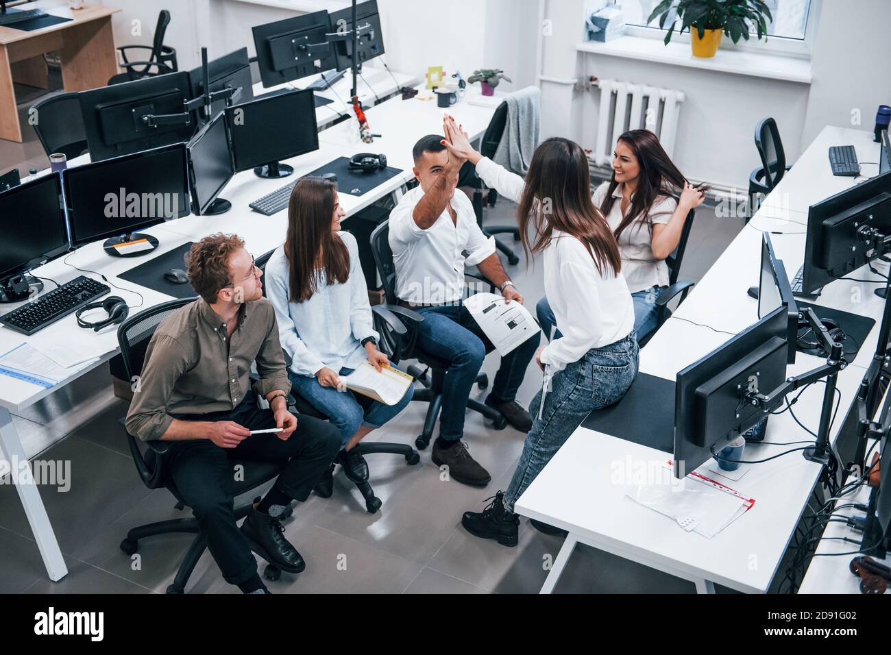 People talking and working together in the modern office near computers ...