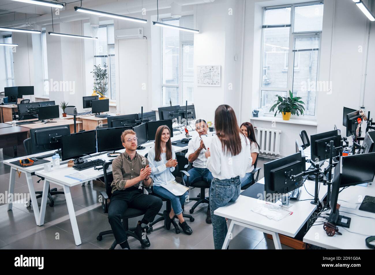 People talking and working together in the modern office near computers ...