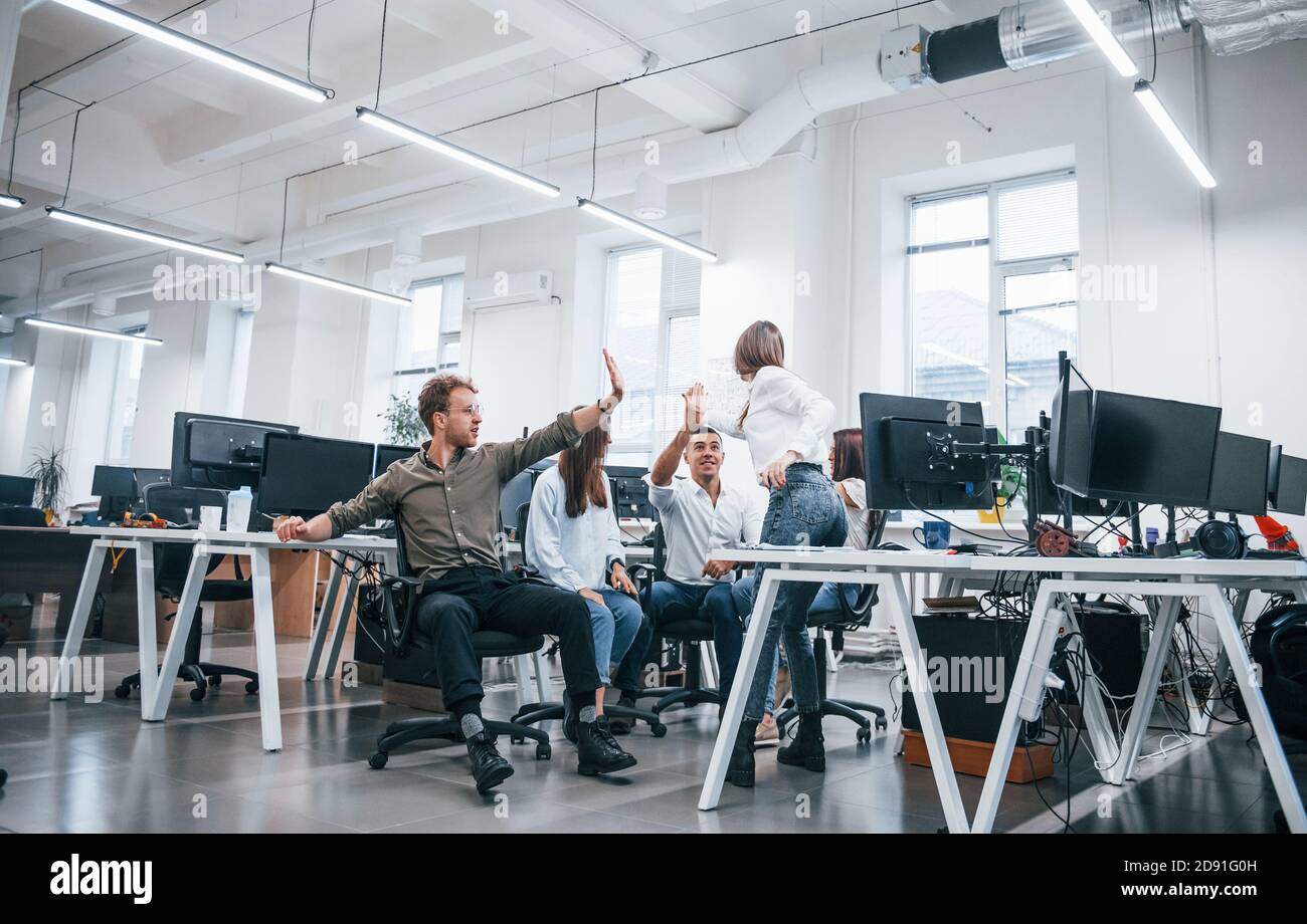 People talking and working together in the modern office near computers ...