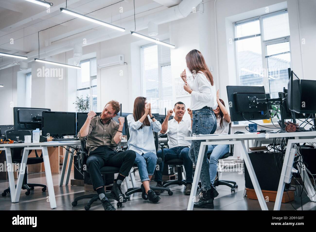 People talking and working together in the modern office near computers ...