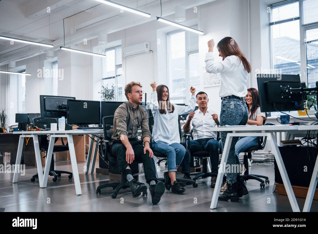 People talking and working together in the modern office near computers ...