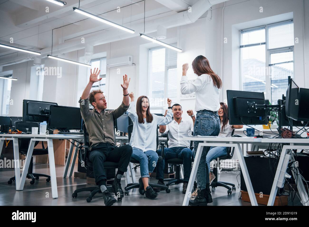 People talking and working together in the modern office near computers ...