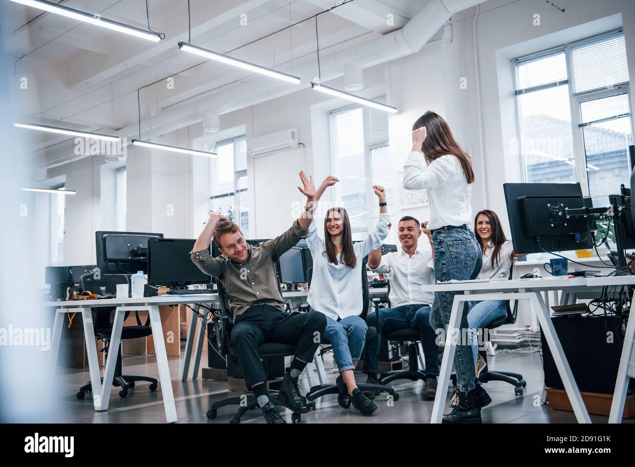 People talking and working together in the modern office near computers ...