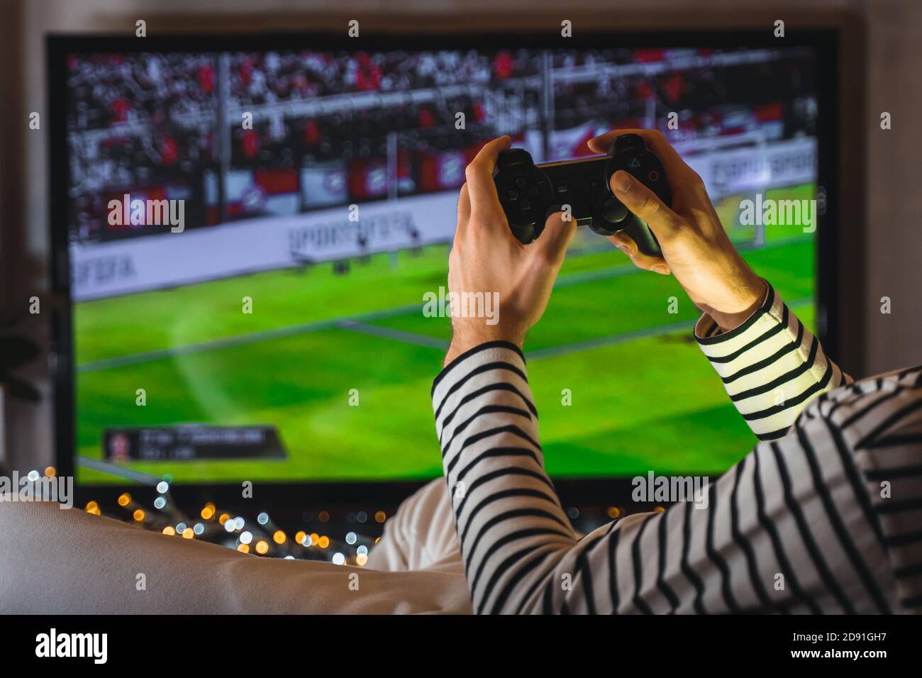 Young hipster man playing video game football soccer on console. gamer ...