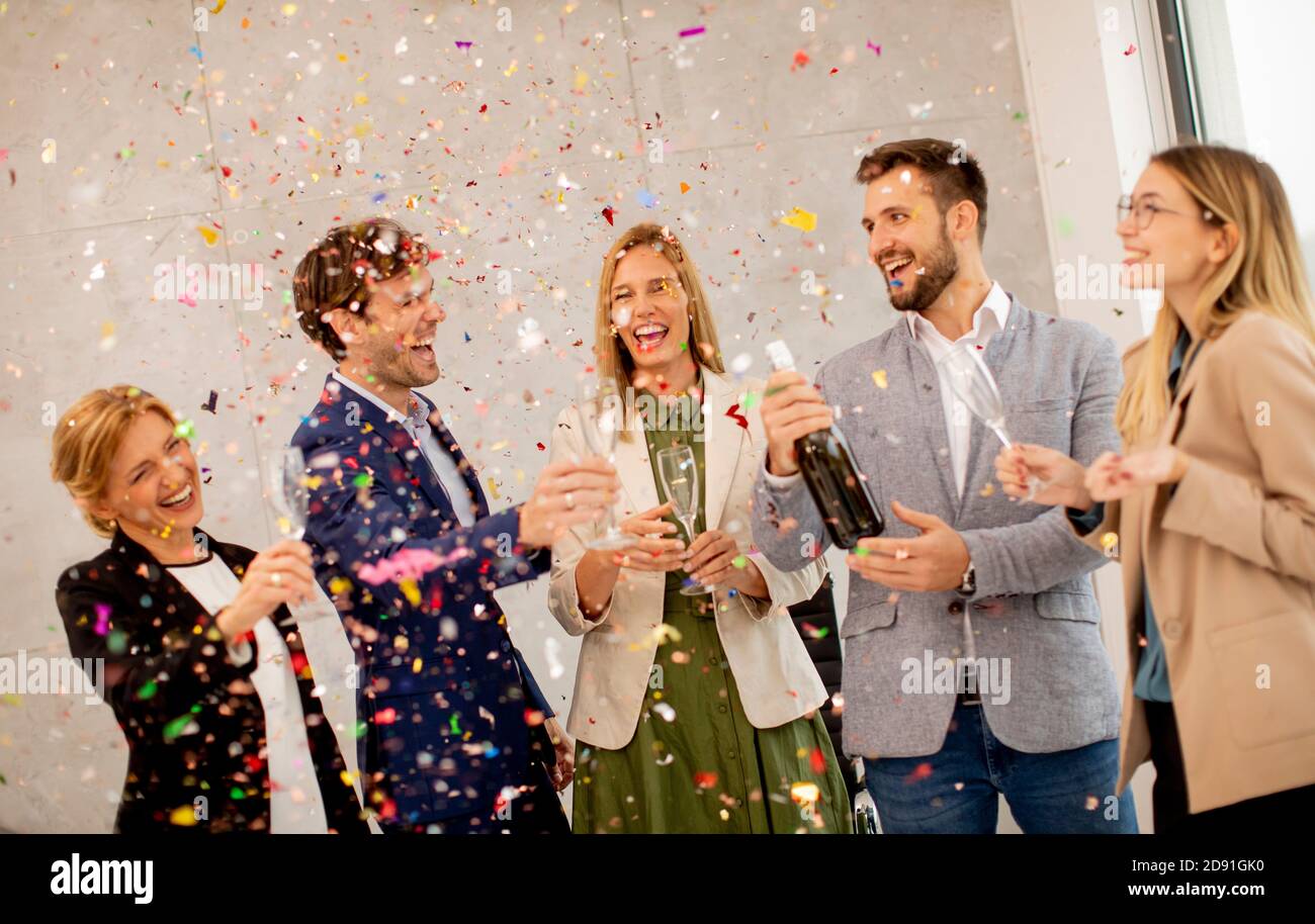 Group of excited business people celebrating and toasting with confetti ...