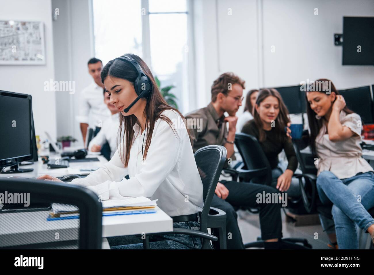 Inside of call center. Young business people working together in the ...