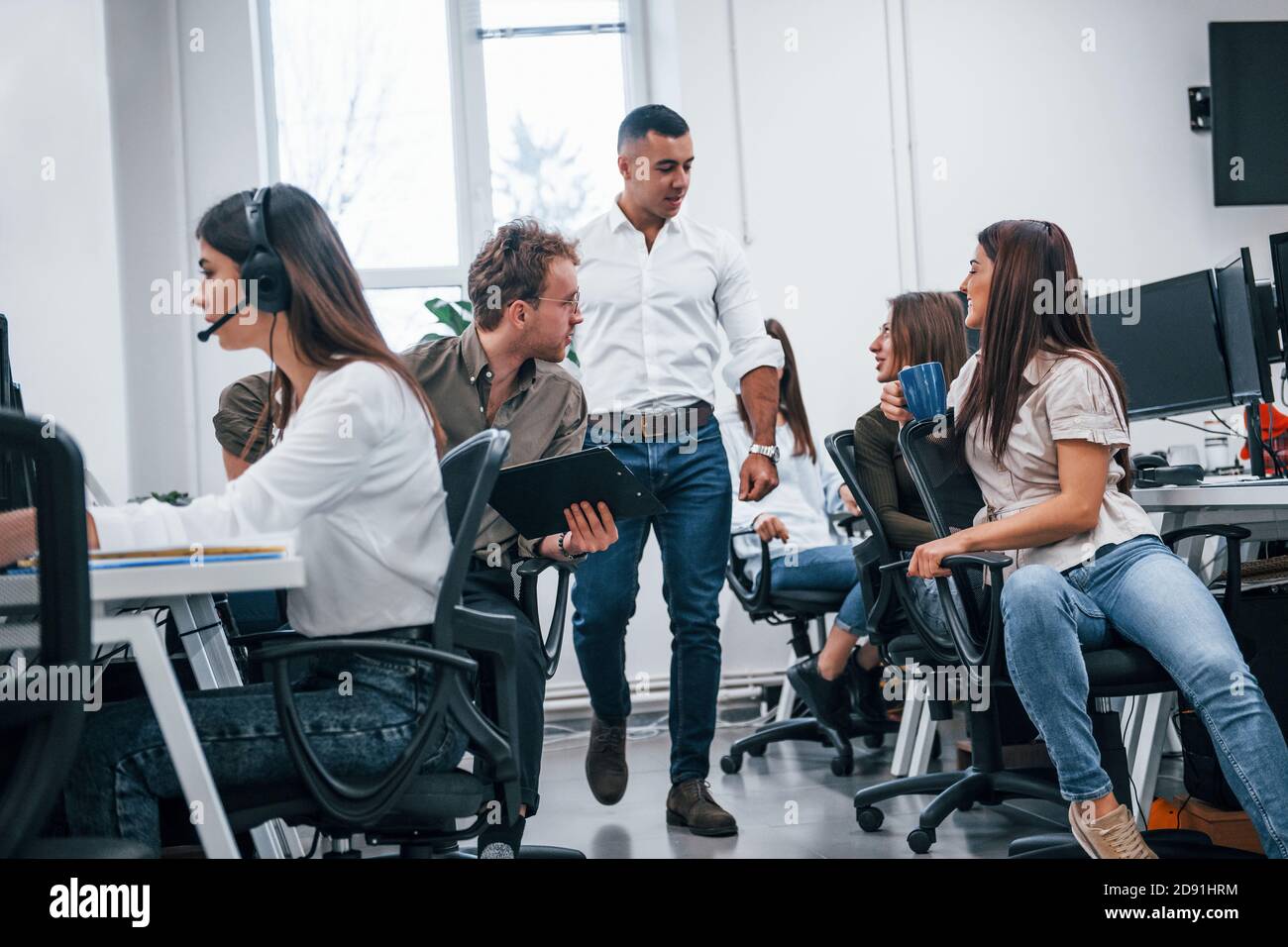 Inside of call center. Young business people working together in the ...