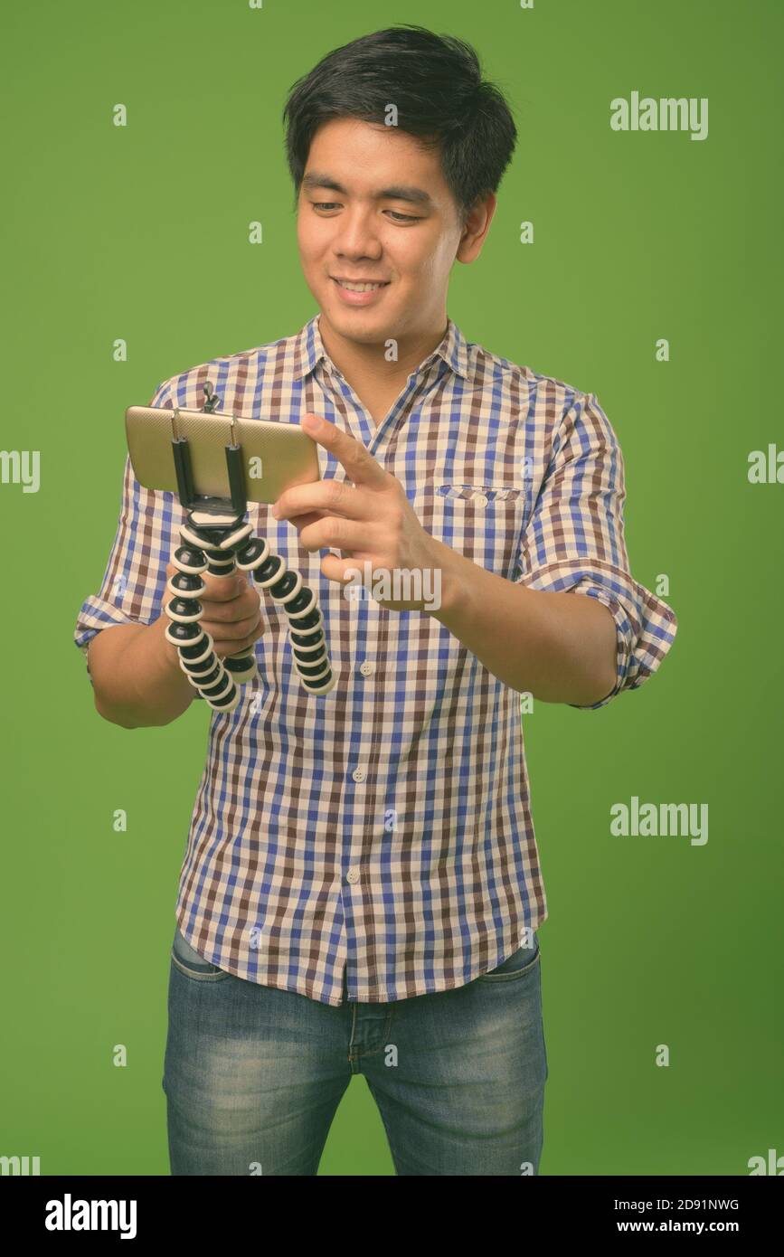 Young handsome Filipino man against green background Stock Photo - Alamy