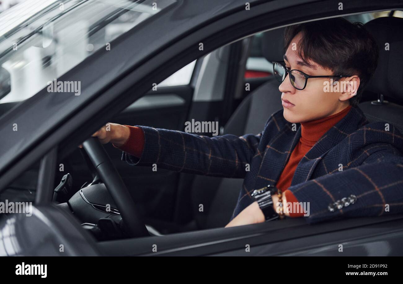 Man in eyewear and formal clothes sitting inside of modern car Stock ...
