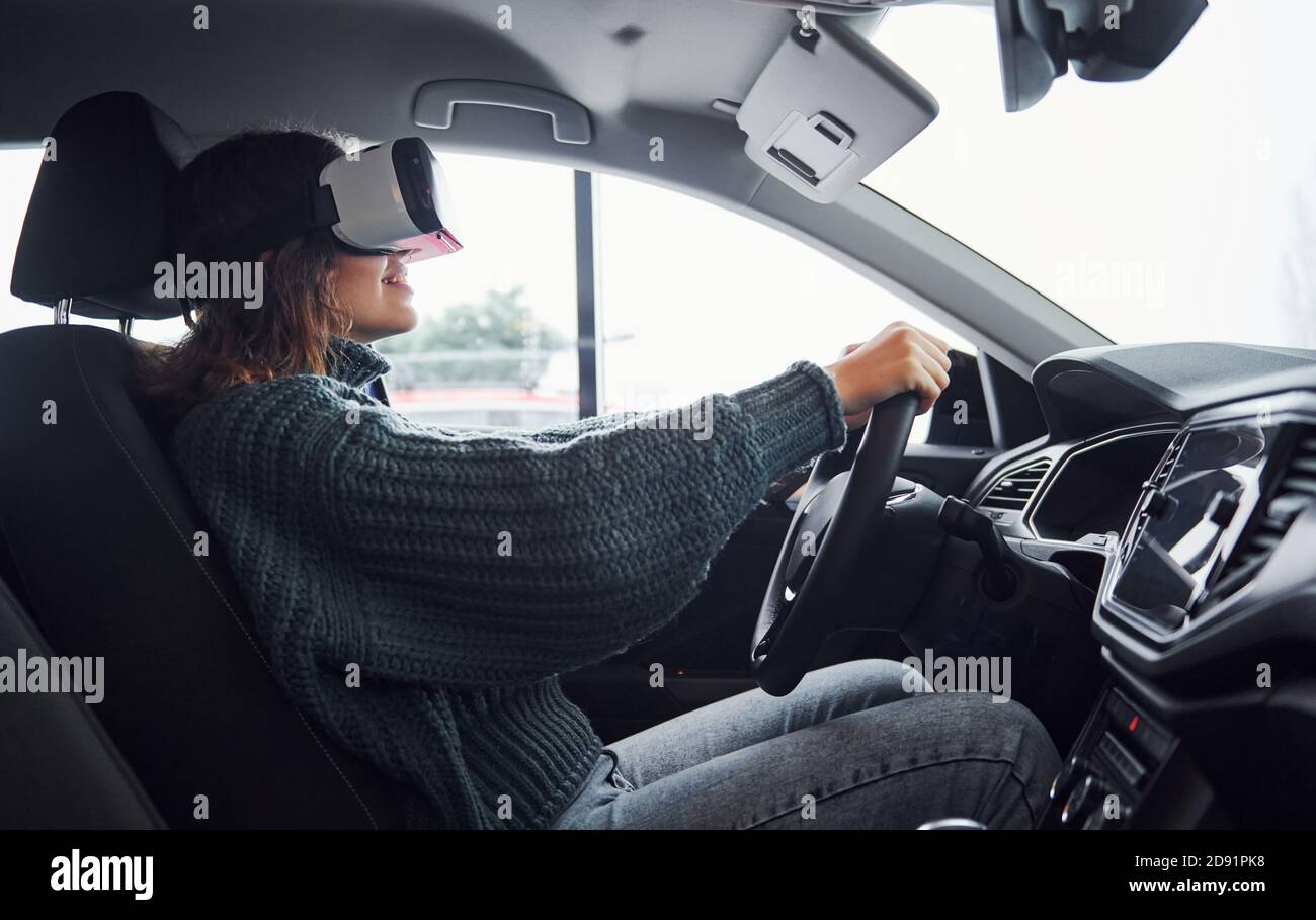 Side view of woman in virtual reality glasses that sitting inside of ...