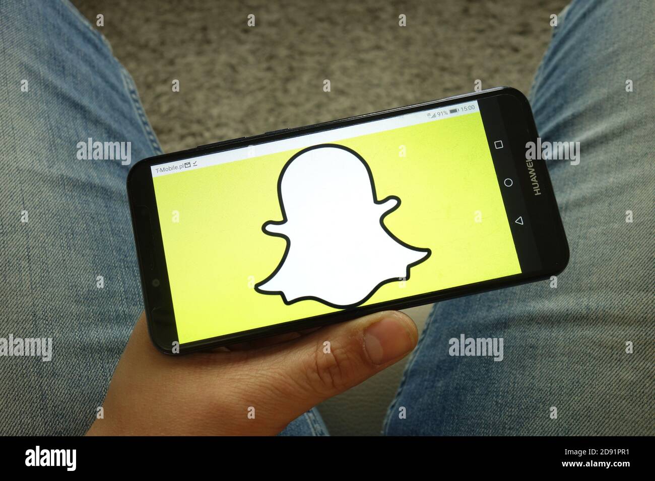 Man holding smartphone with Snapchat messaging app logo Stock Photo - Alamy