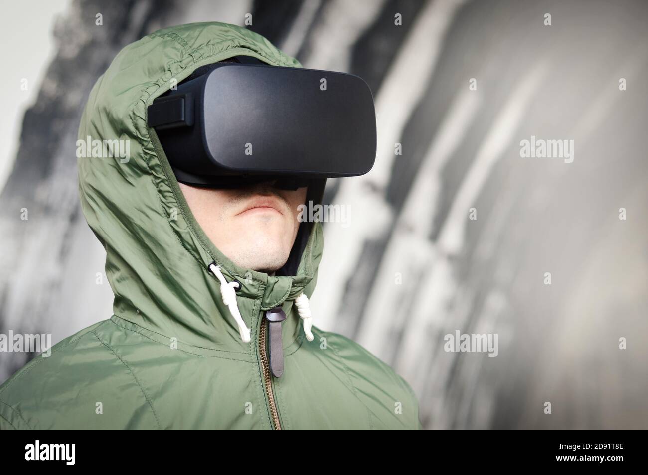 serious young man with a virtual reality headset in a green protective ...