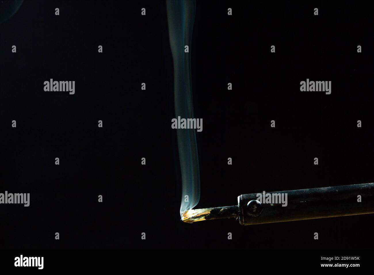 soldering iron with smoke from the sting of burning rosin . Photo on a ...