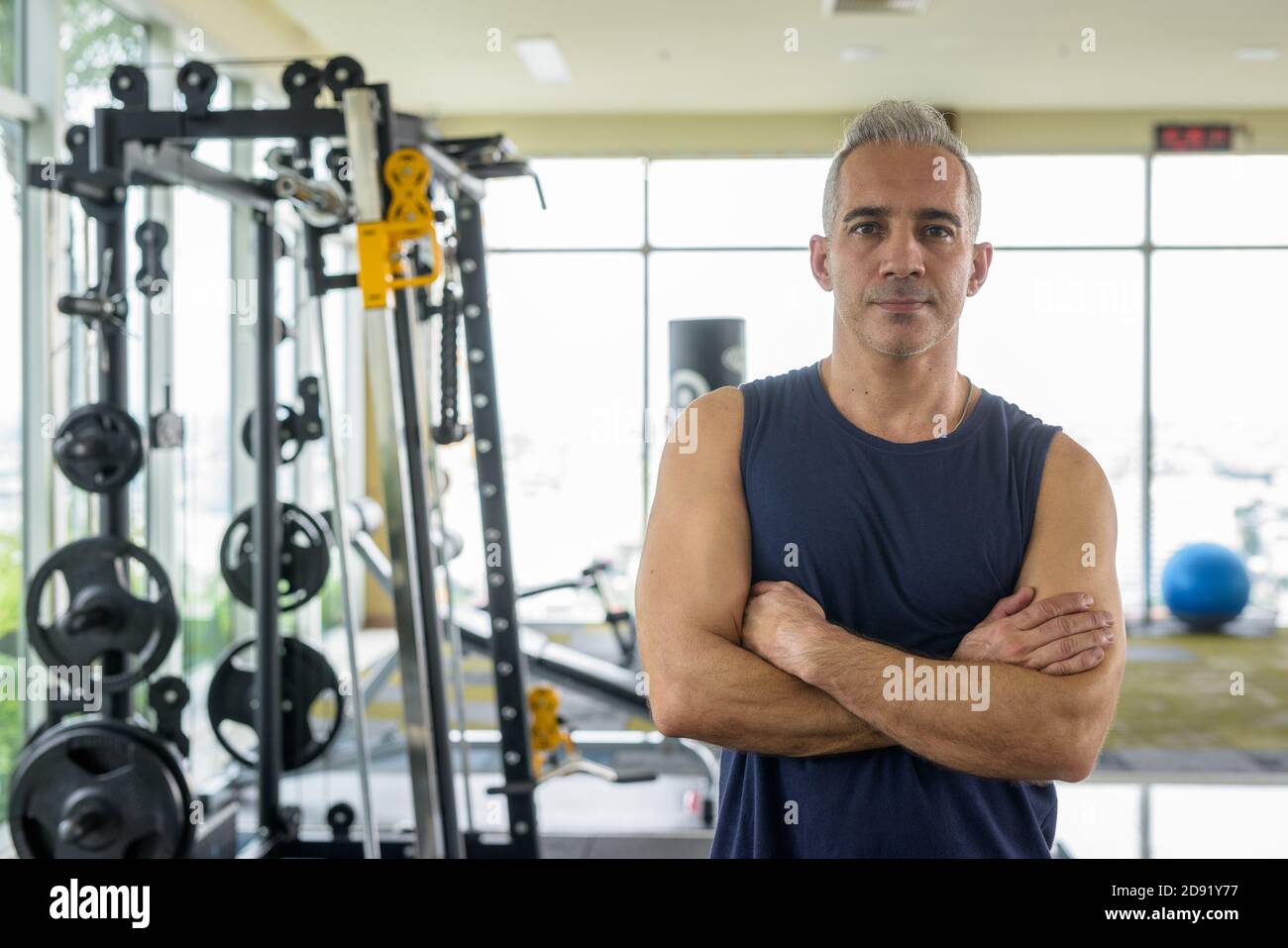 Mature handsome Persian man with arms crossed at the gym Stock Photo ...