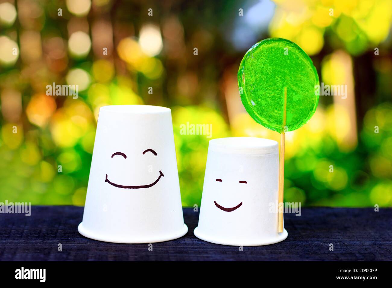 Two smiling cups with green lollipop. Emotion of joy, symbol of ...